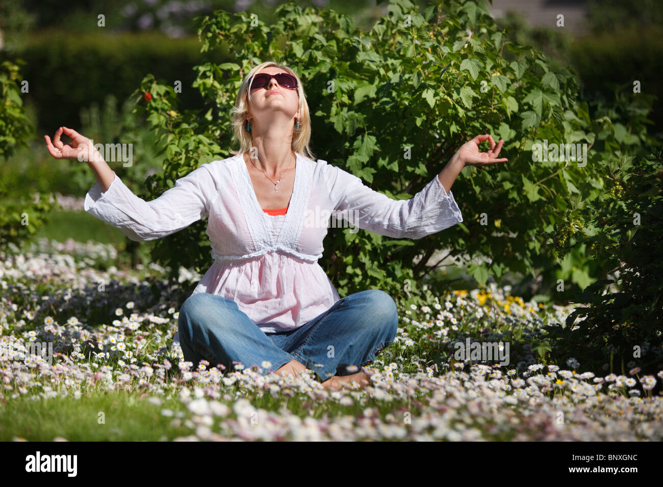 Girl in garden between flowers Stock Photo - Alamy