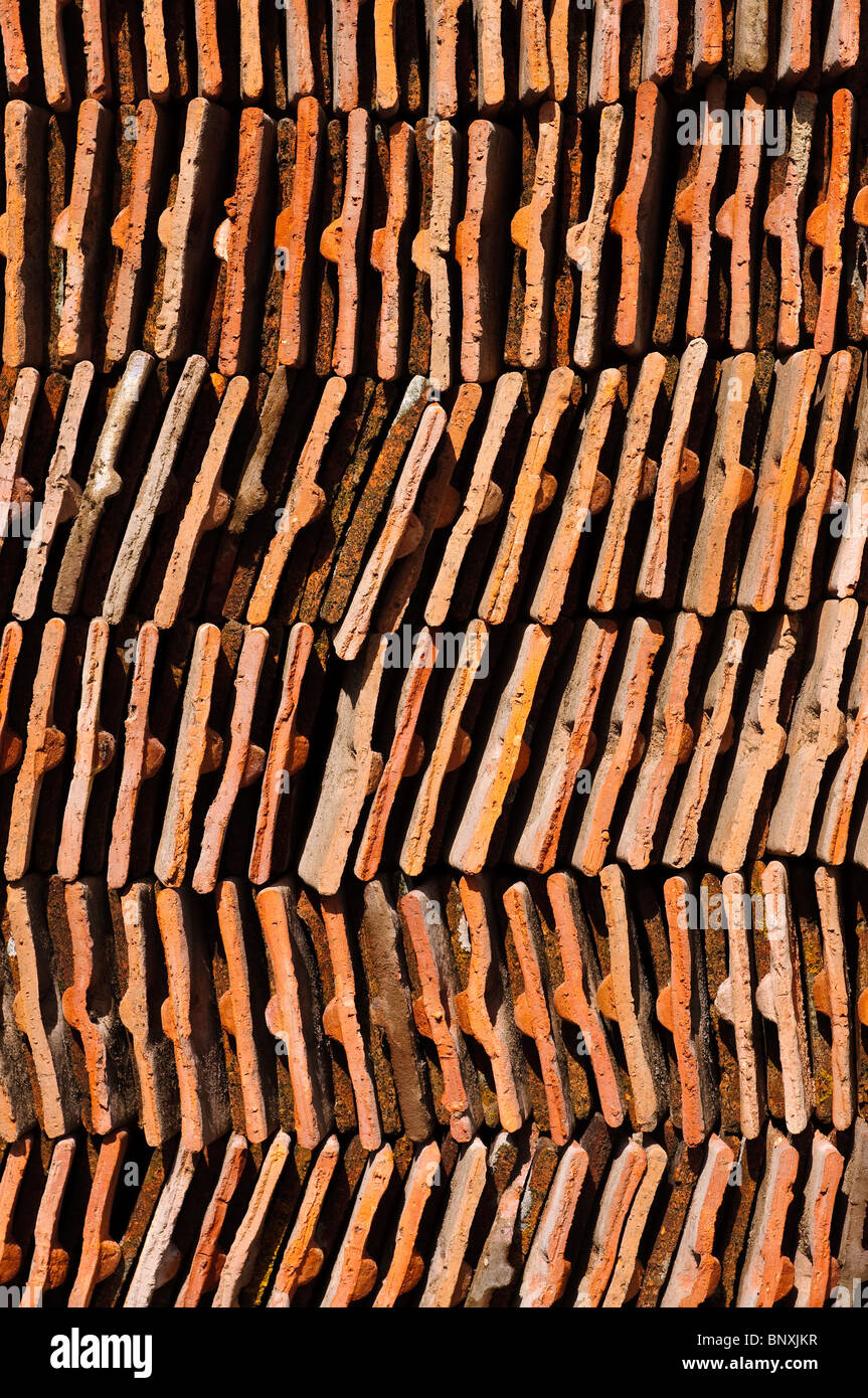 Stack of reclaimed old traditional red clay roofing tiles - France ...