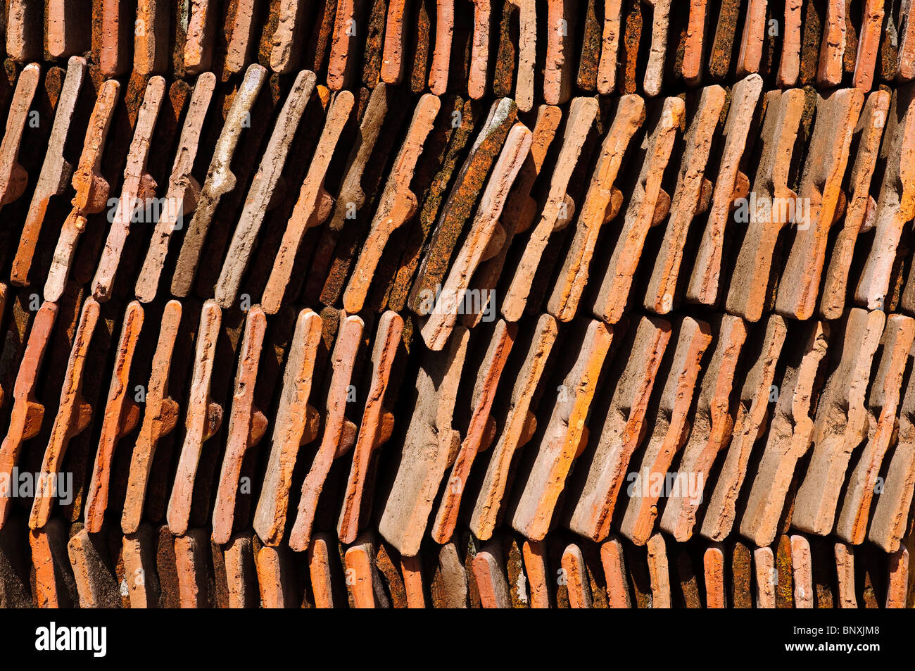 Stack of reclaimed old traditional red clay roofing tiles - France ...