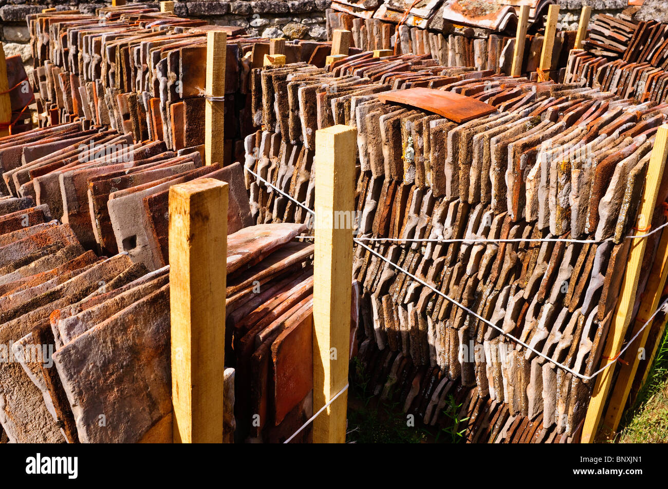 Stacks of reclaimed old traditional red clay roofing tiles - France ...