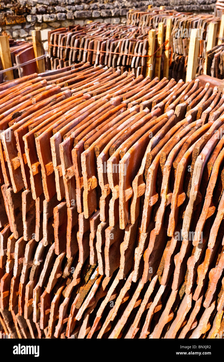 Stacks of reclaimed old traditional red clay roofing tiles - France ...