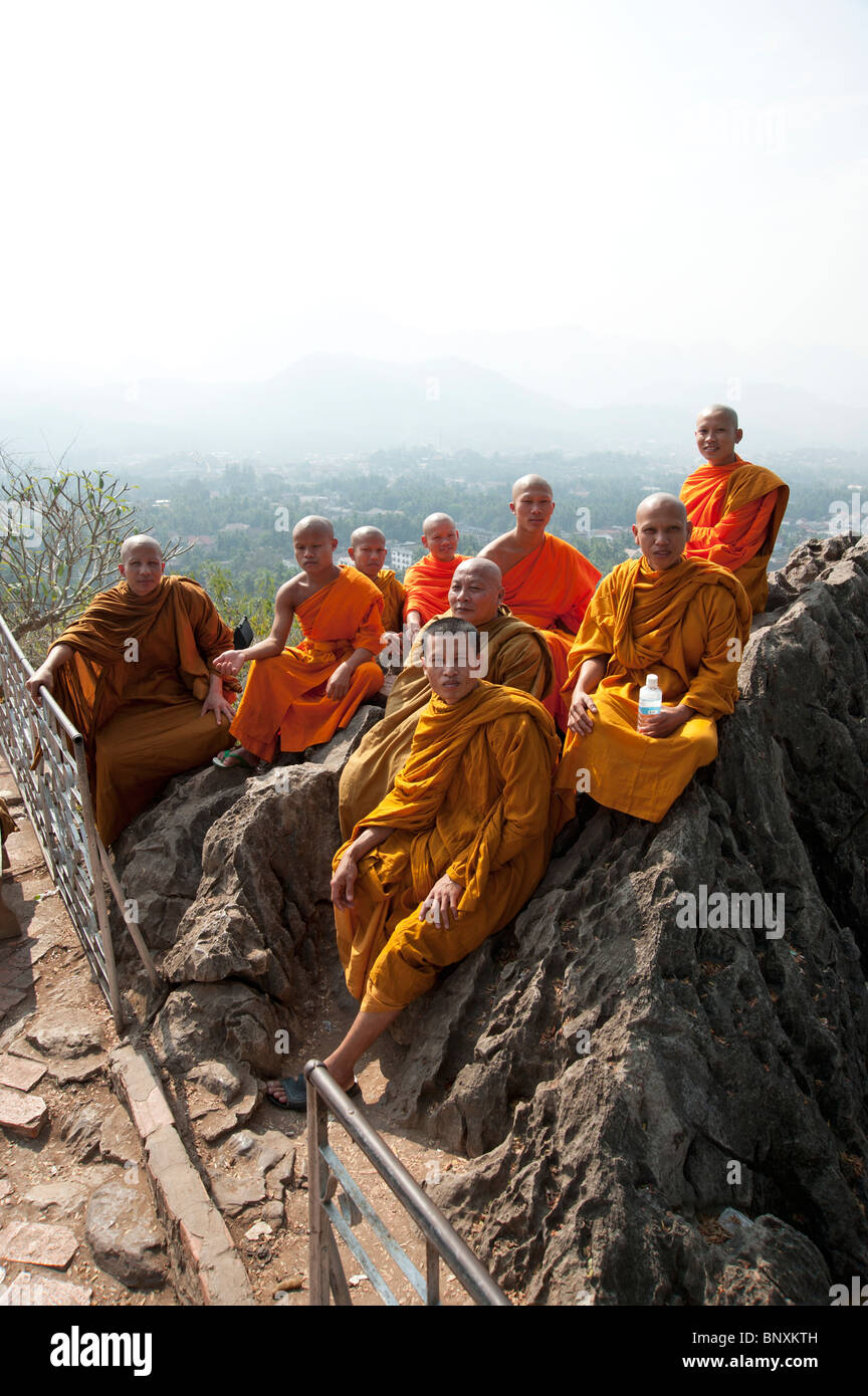 Nine monks sit on top of rocks in laos hi-res stock photography and ...