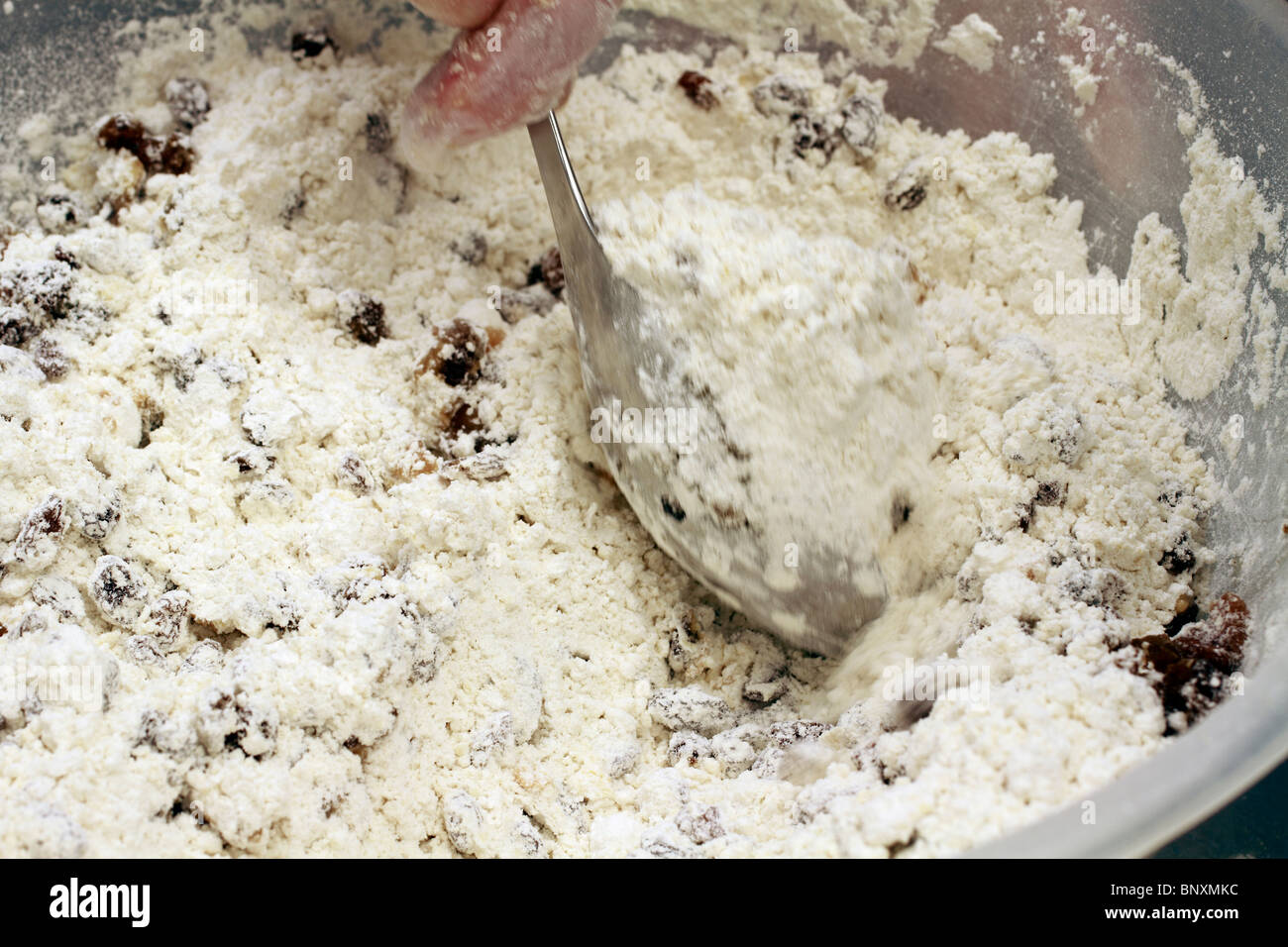 Making scones - mixing in the raisins by hand Stock Photo - Alamy