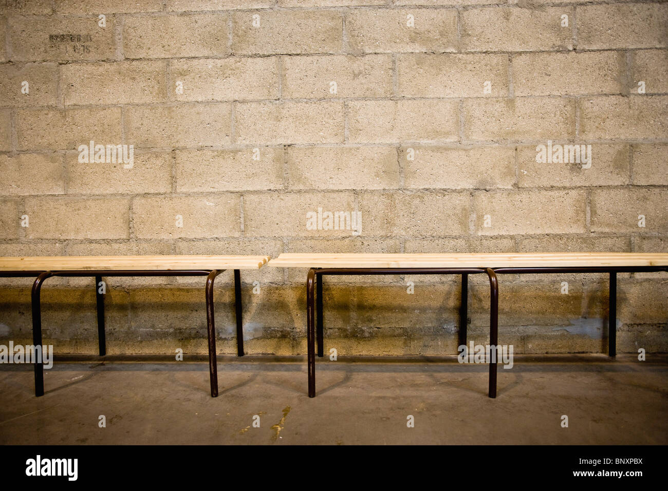 Benches against brick wall Stock Photo - Alamy