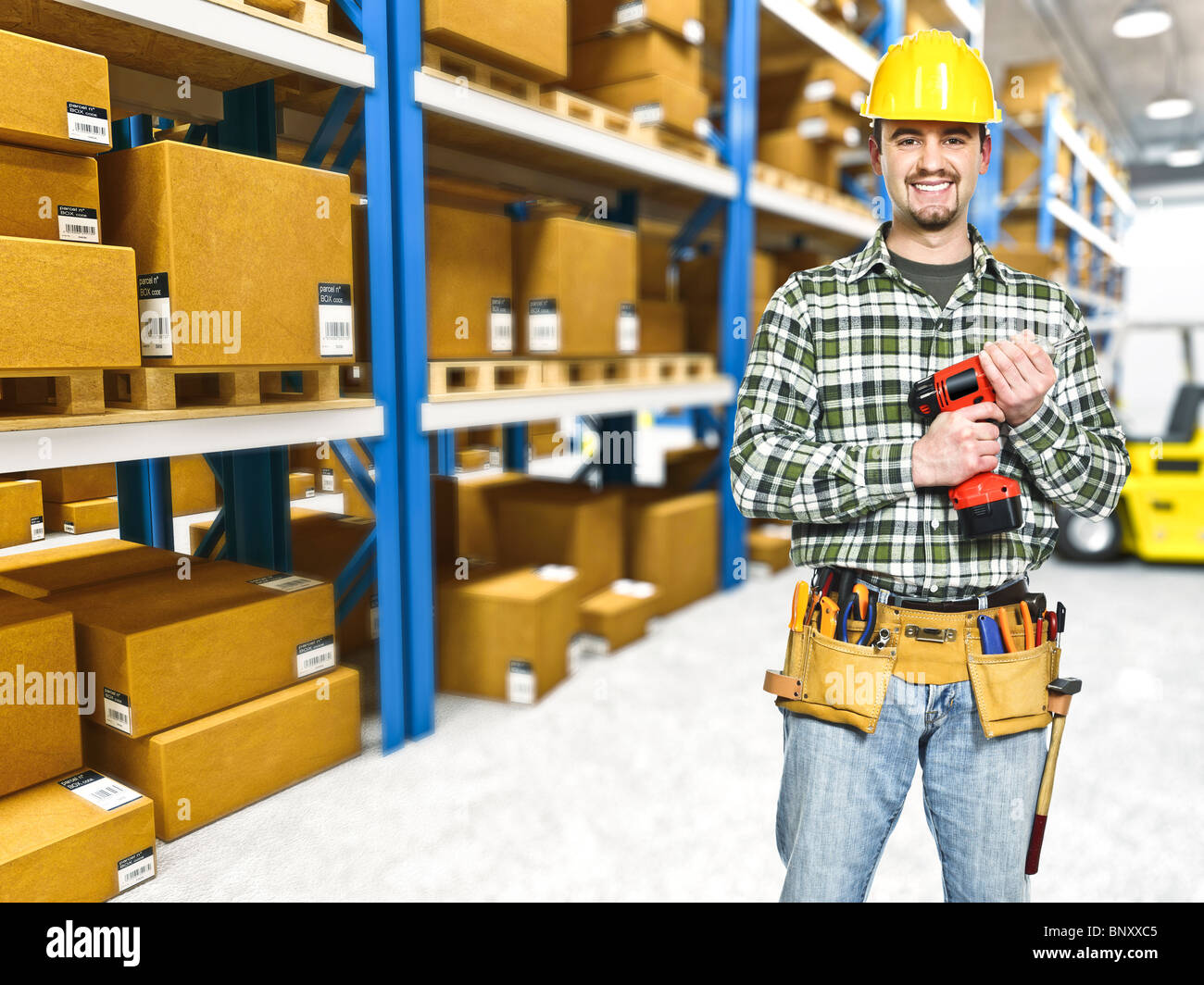 standing handyman with red drill and warehouse background Stock Photo ...