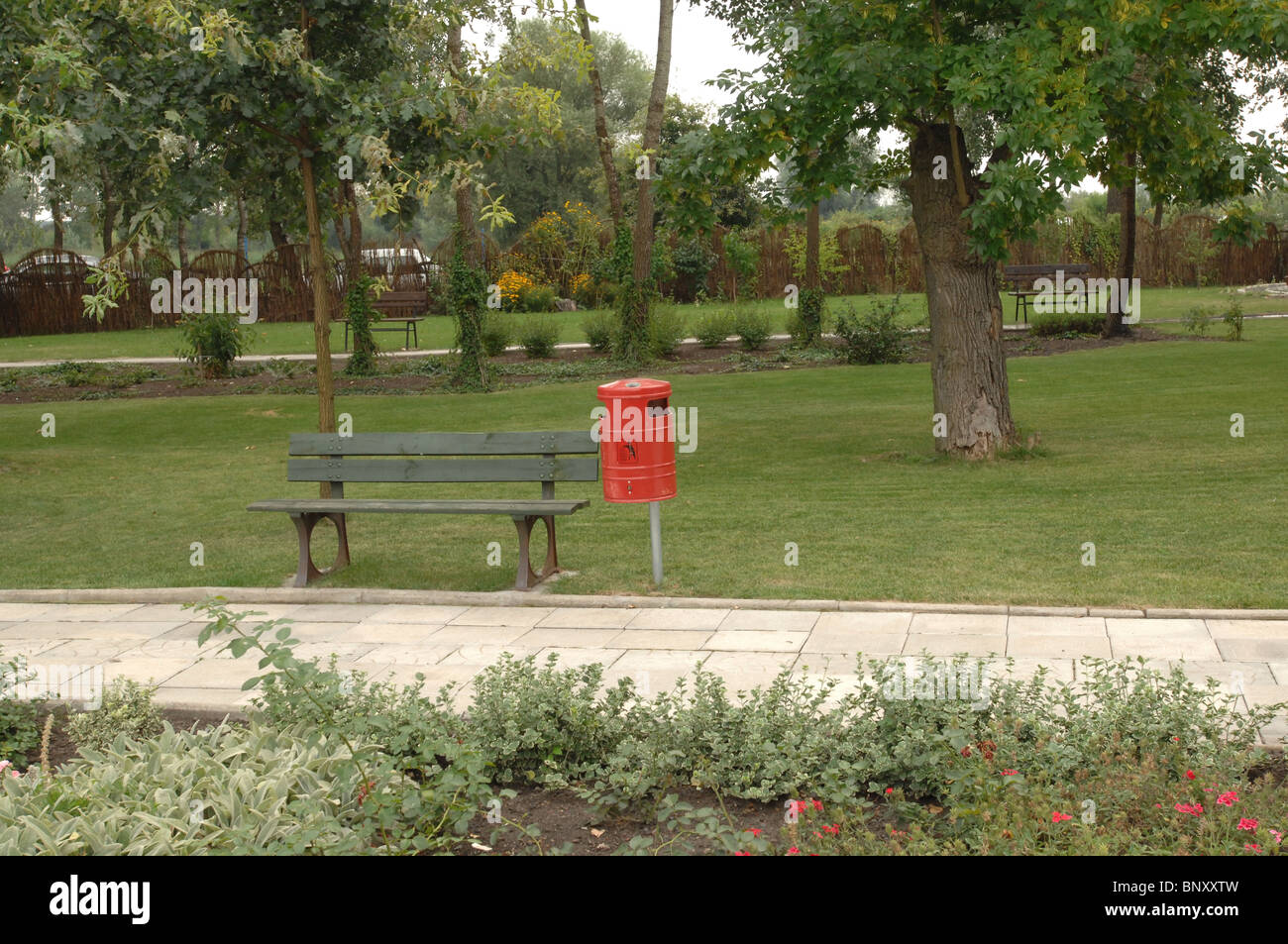 Park bench and litter container in a tidy park park in Nowa Sol, Poland ...