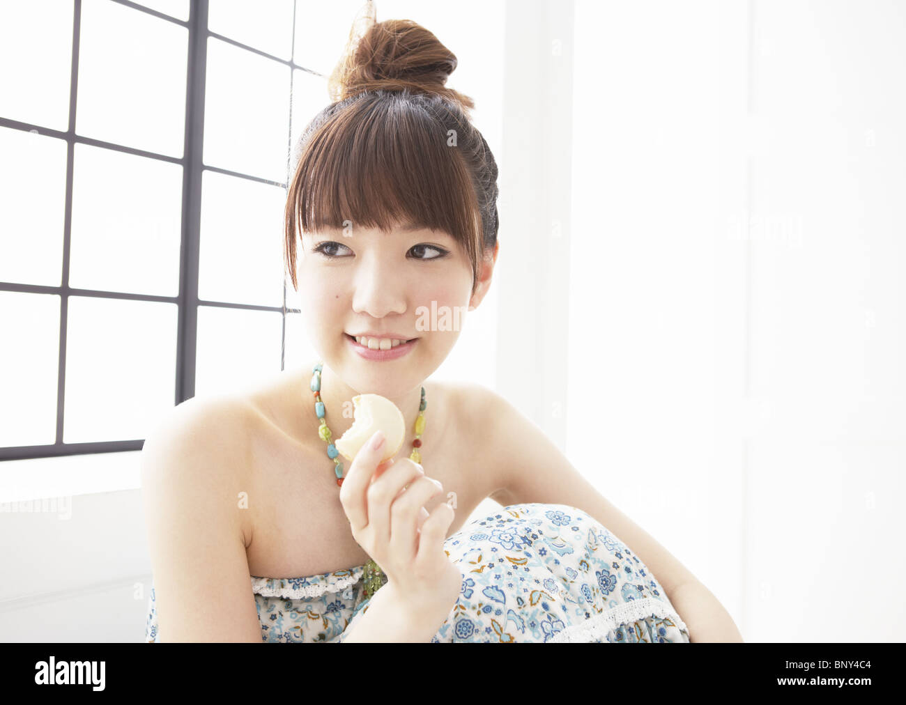 Young woman eating macaroon Stock Photo - Alamy