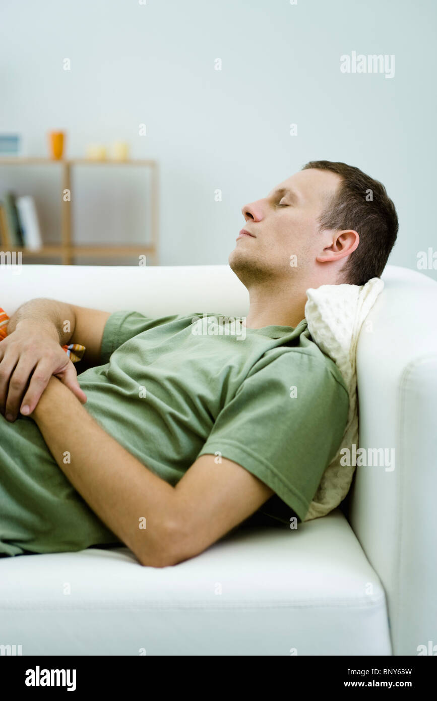 Man napping on sofa Stock Photo - Alamy