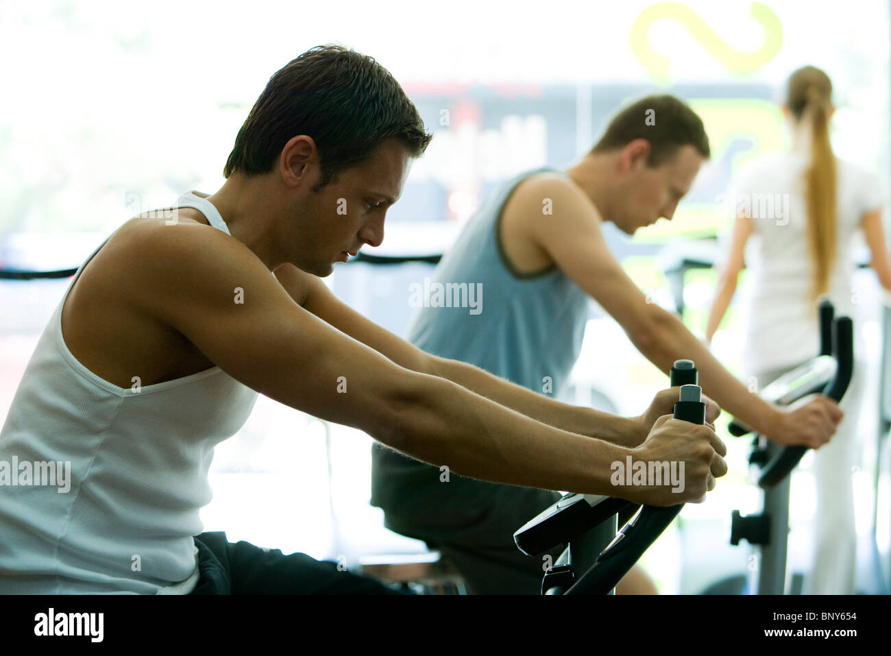 Men on exercise bikes in gym Stock Photo - Alamy
