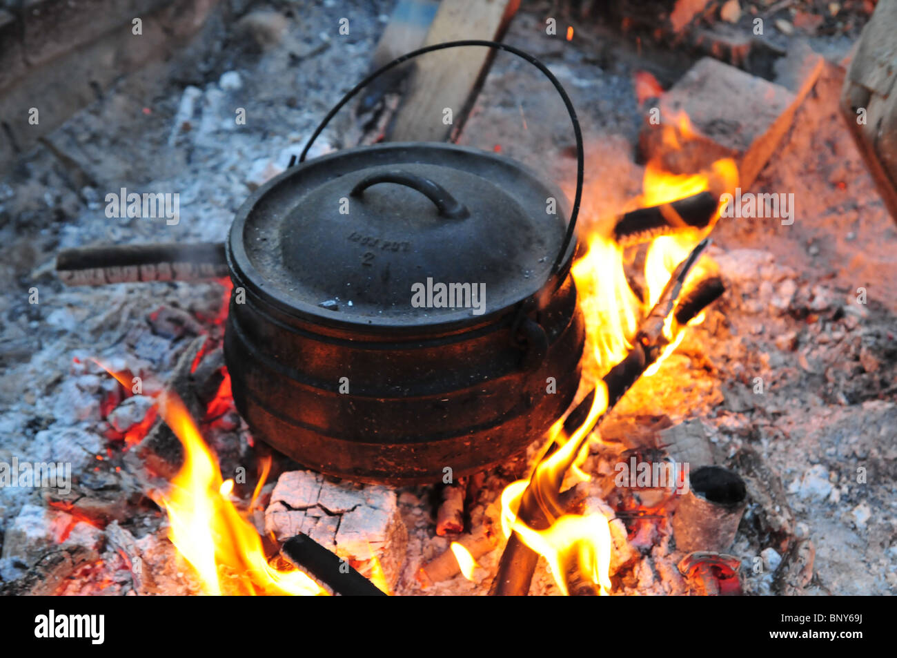 Cooking on an open fire, an iron caldron on an outdoor wood fire, hand ...