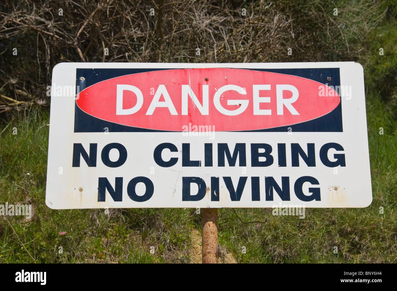 DANGER NO CLIMBING NO DIVING sign next to coastal cliffs Stock Photo ...