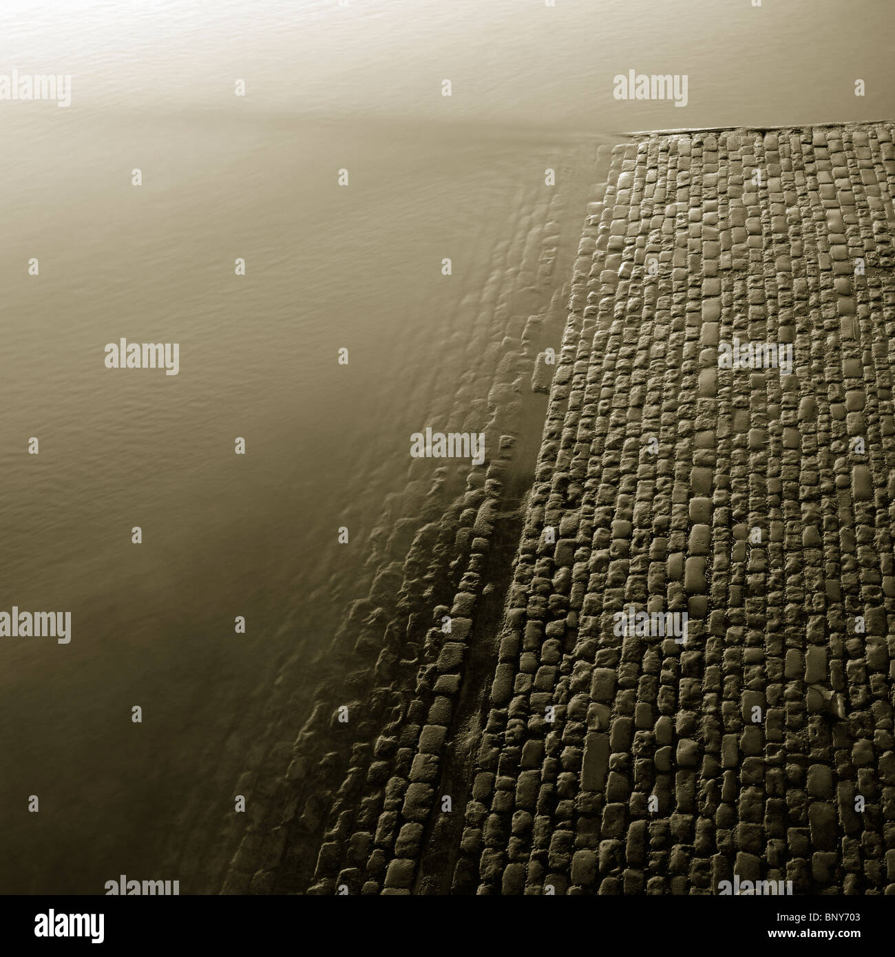 Water by cobbled path Stock Photo - Alamy