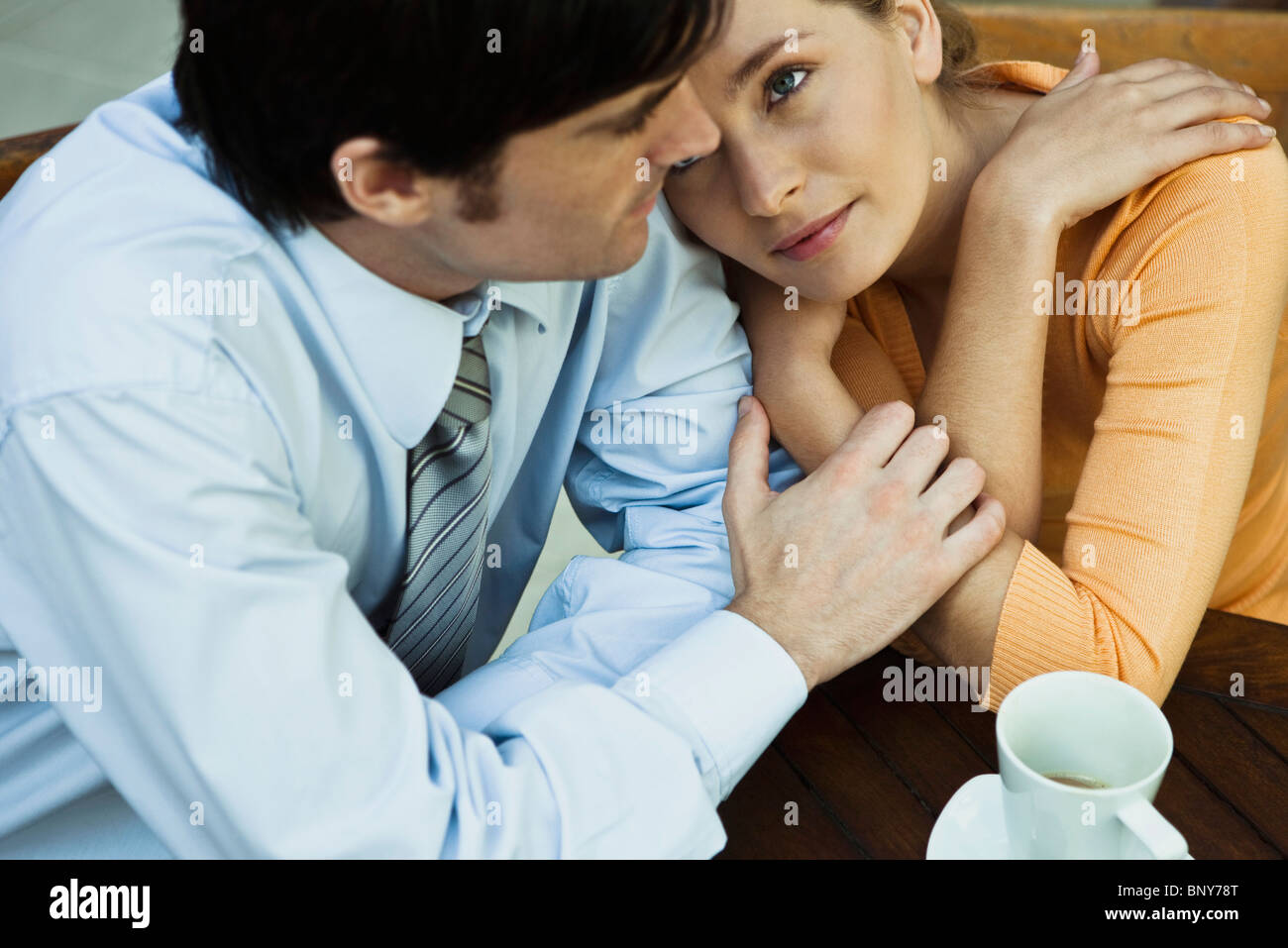 Couple sitting together in cafe, woman resting her head on man's ...