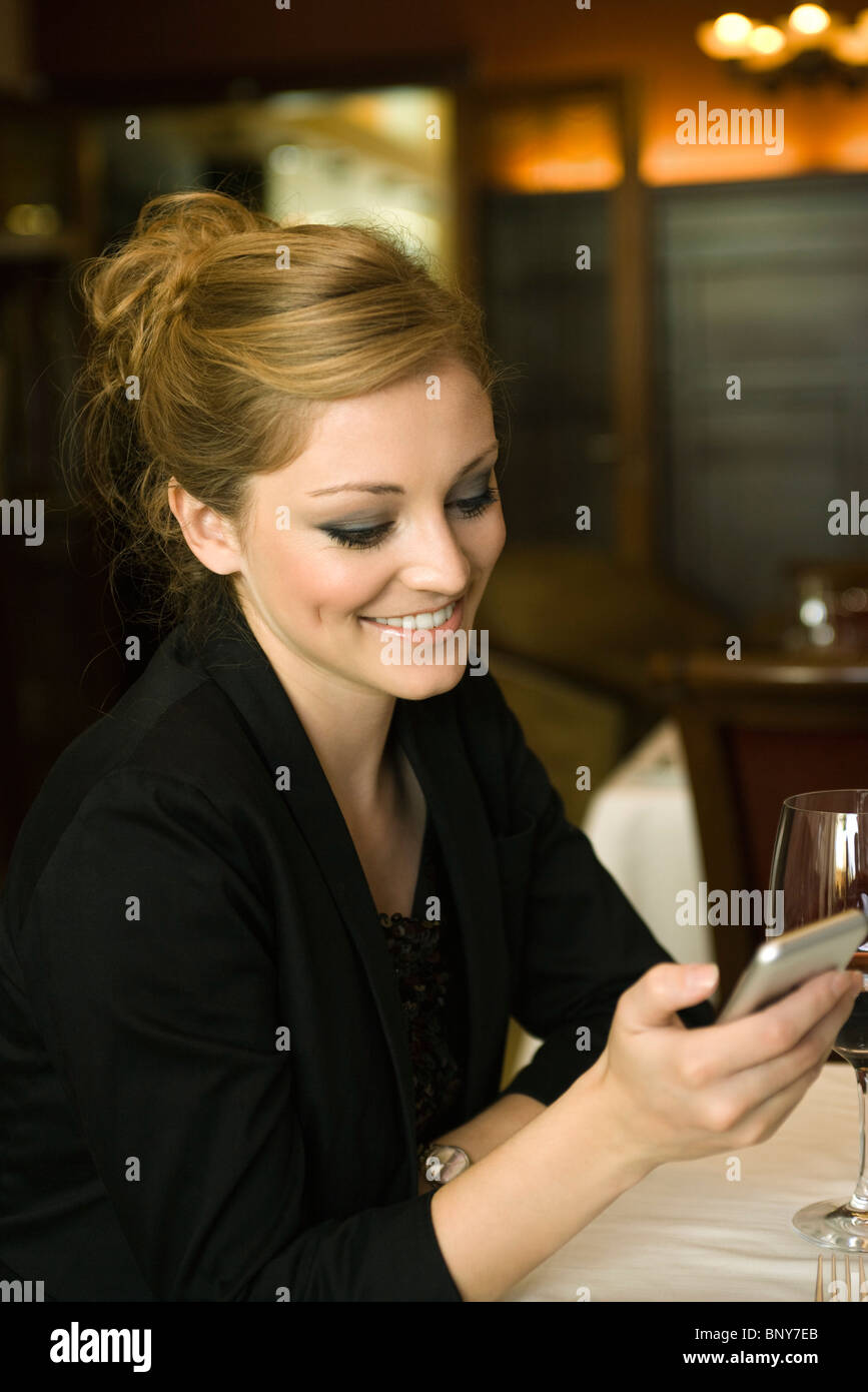 Woman text messaging in restaurant Stock Photo - Alamy
