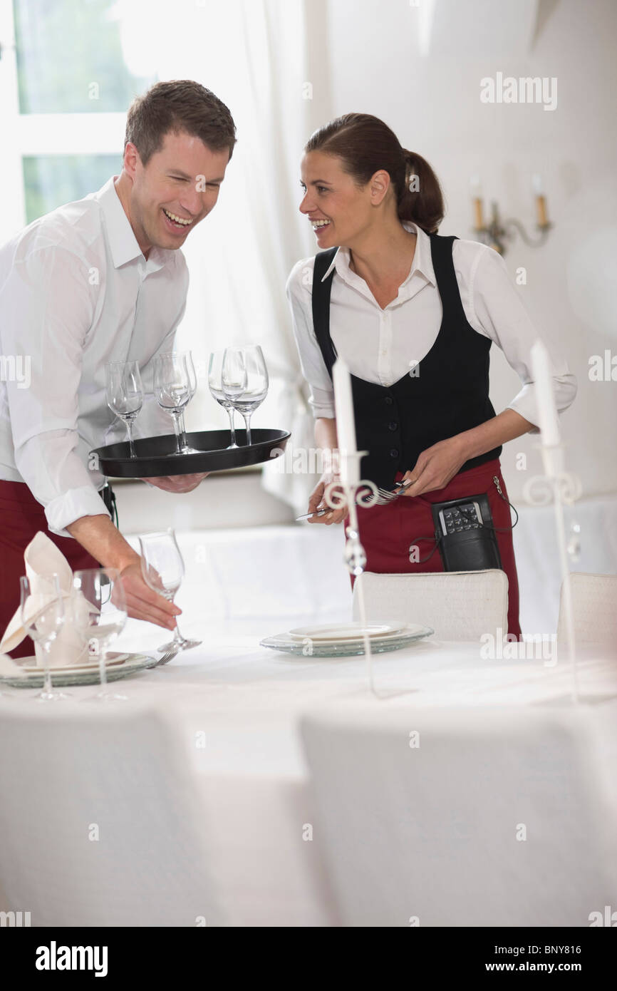 Waiter and waitress laying the table Stock Photo - Alamy