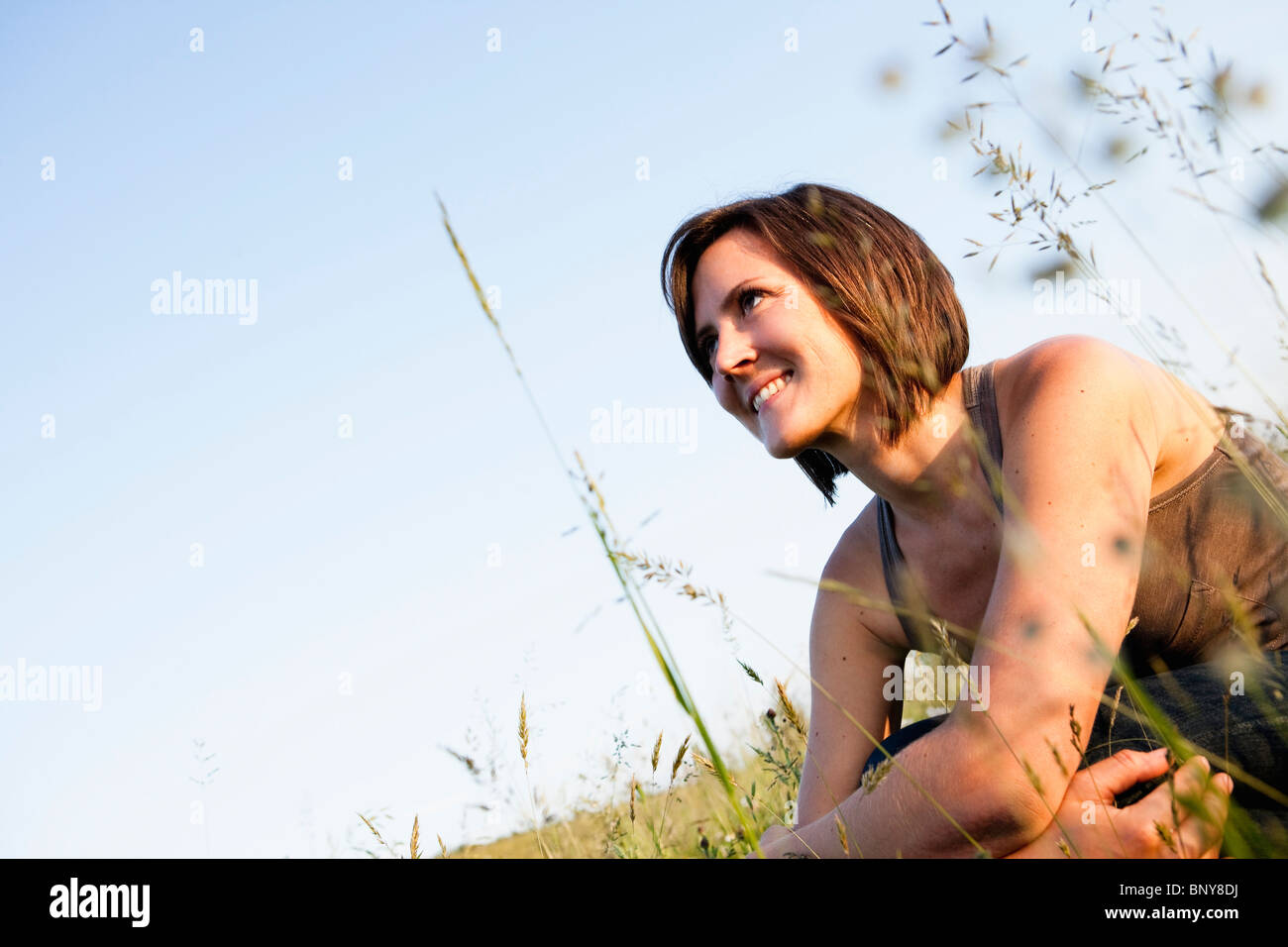 Woman relaxing in field Stock Photo - Alamy