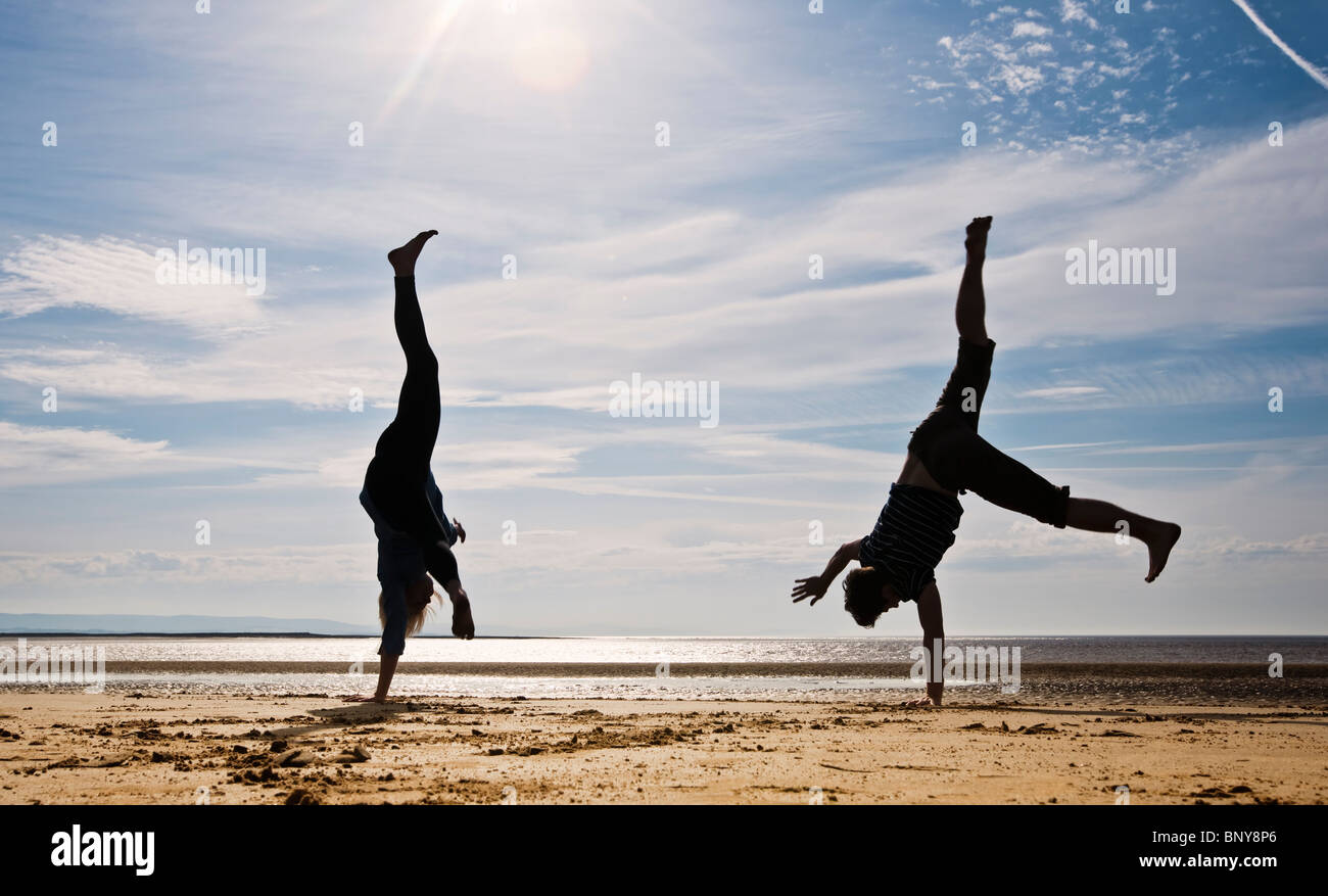 two people cartwheeling on beach Stock Photo - Alamy