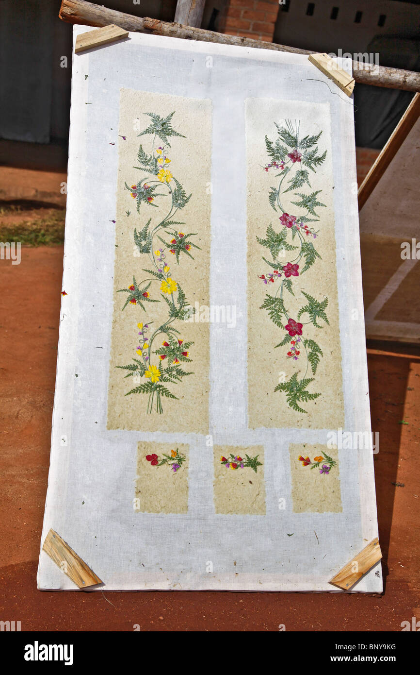 Handmade paper with inlaid petals and leaves out drying on a stretcher ...