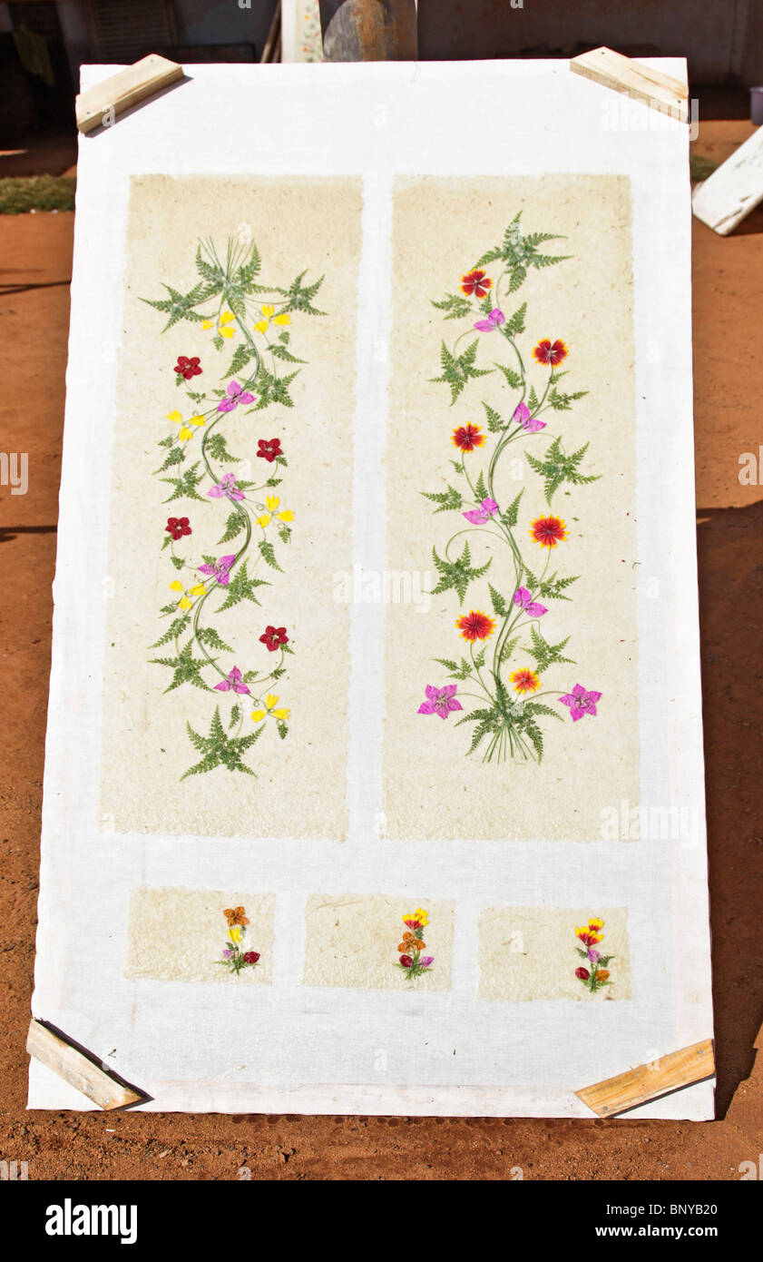 Handmade paper with inlaid petals and leaves out drying on a stretcher ...