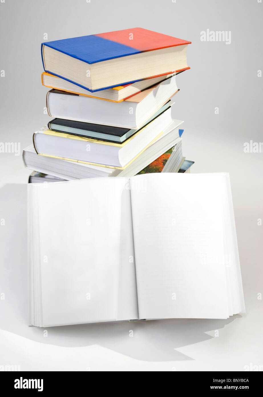 Blank opened book w background of pile of books Stock Photo - Alamy