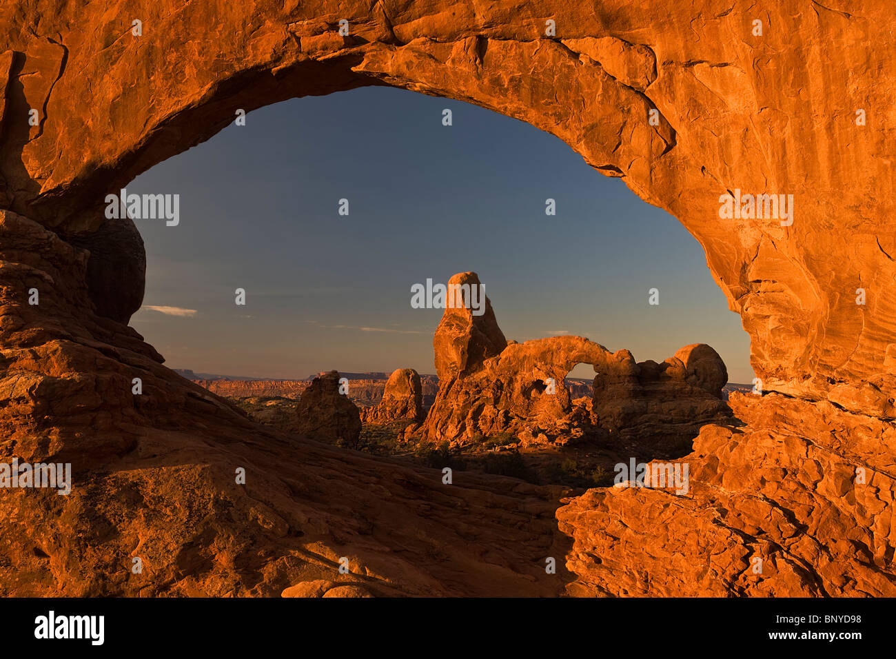 Warm sunrise light illuminates Turret Arch as seen through North Window ...