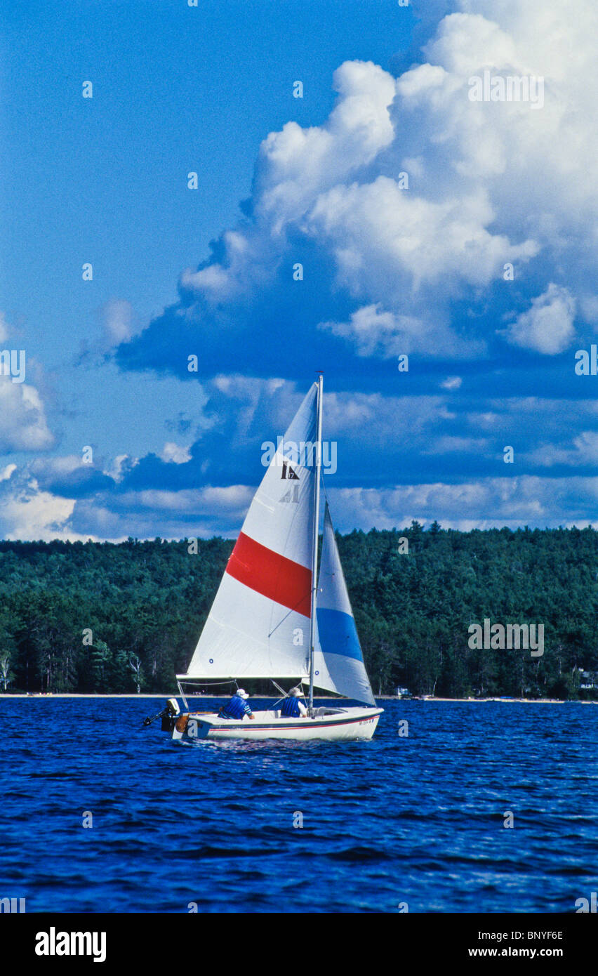 Two people, man woman navigate small sail boat Stock Photo - Alamy