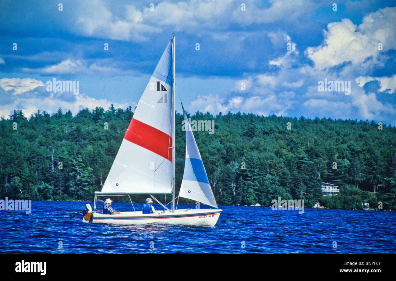Two people, man woman navigate small sail boat Stock Photo - Alamy
