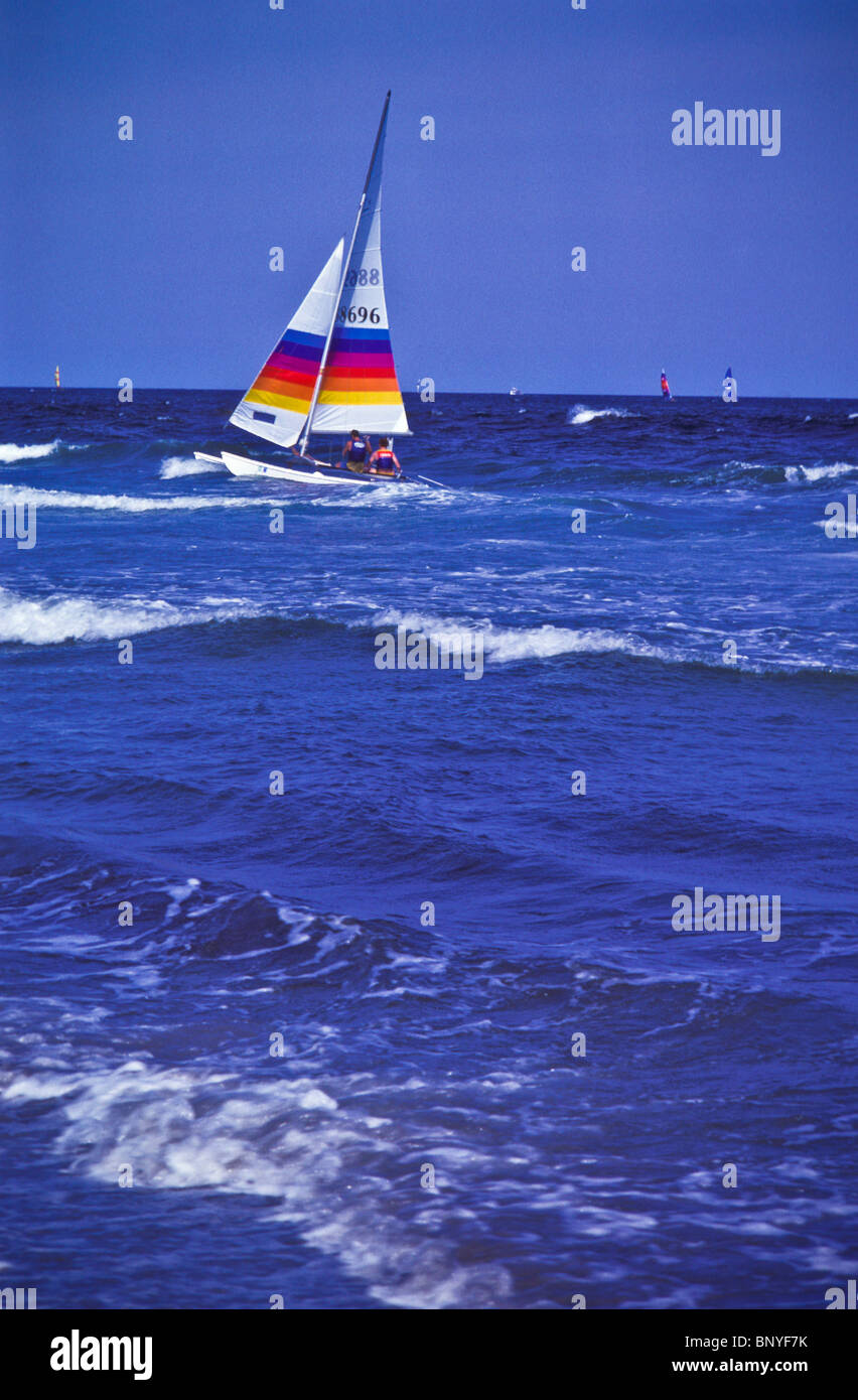 Blue ocean waves, small colorful sail boat Stock Photo - Alamy