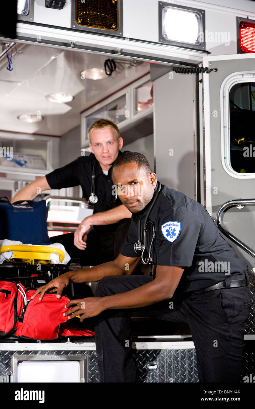 Multiracial paramedics preparing medical equipment in ambulance Stock ...
