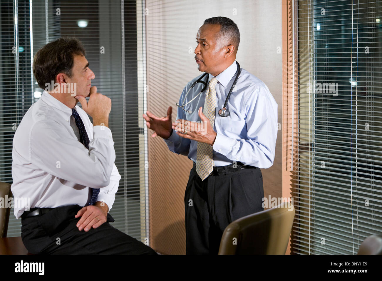 Two medical professionals conversing in office Stock Photo - Alamy