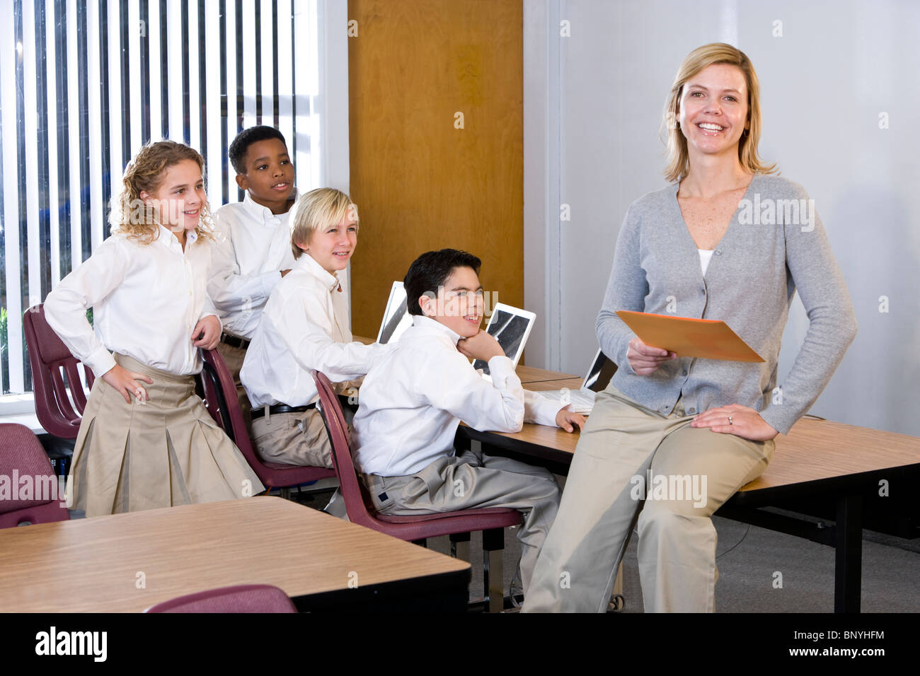 Diverse elementary school students in classroom with teacher Stock ...