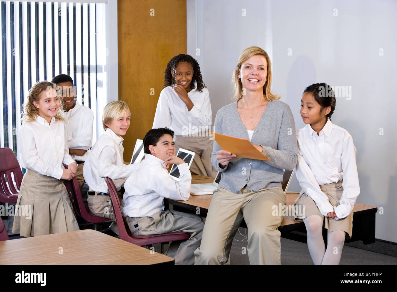 Diverse elementary school students in classroom with teacher Stock ...