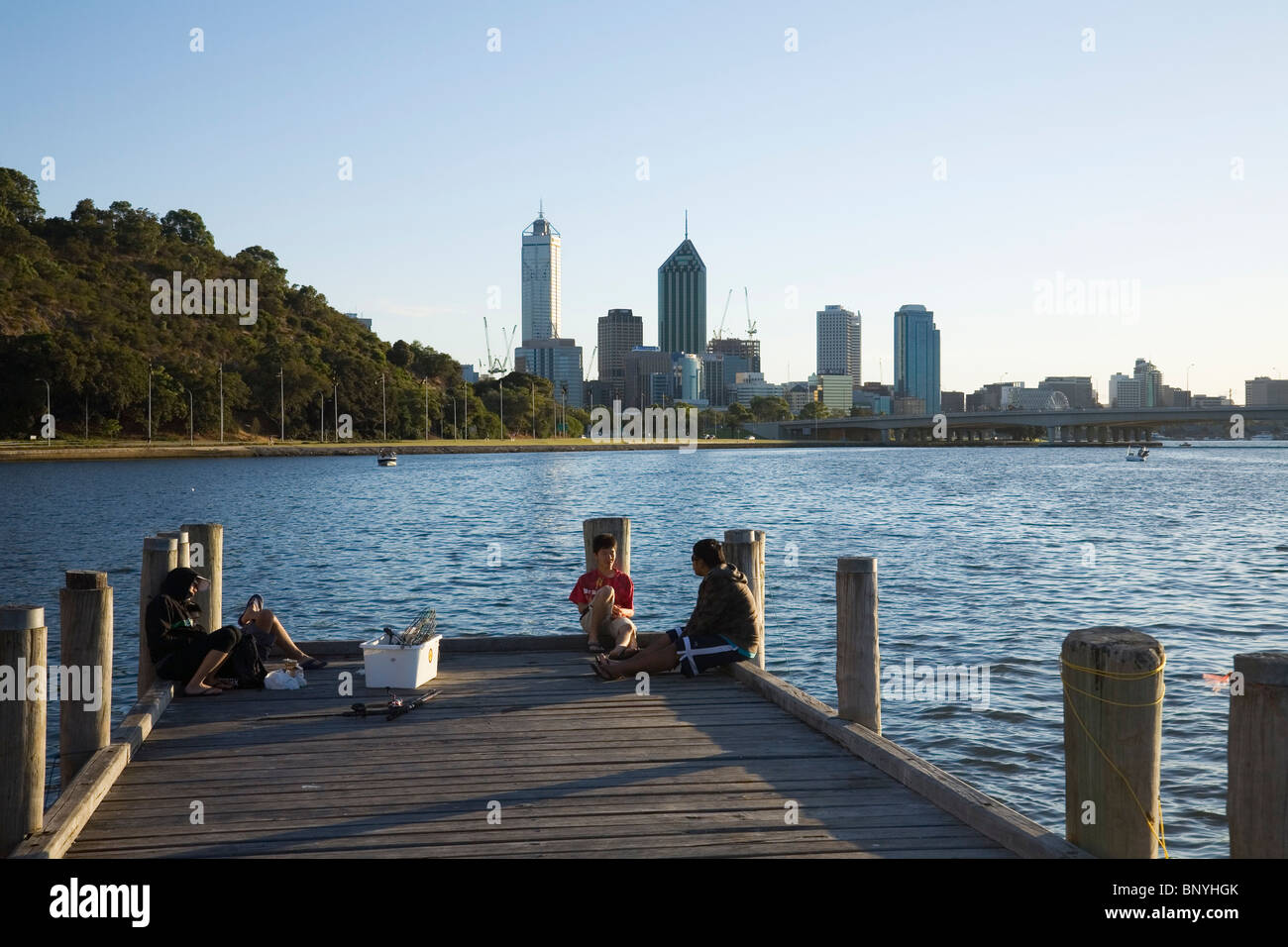 Wooden jetty on the Swan River with a view of the city skyline. Perth ...