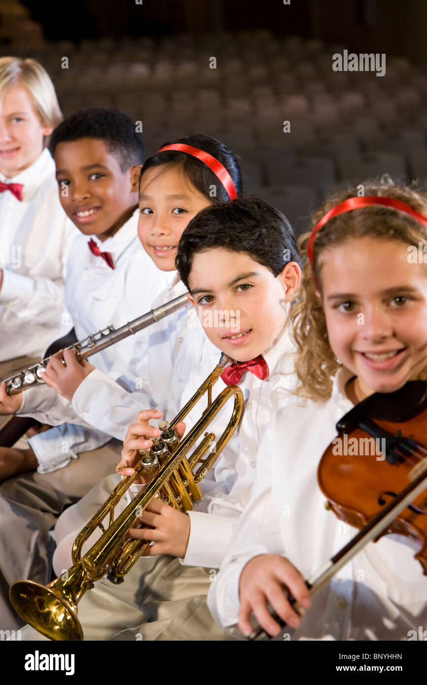 Young students playing musical instruments in school auditorium Stock ...