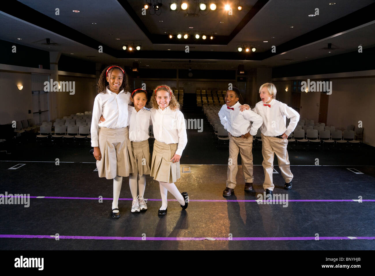 Group of school children standing on auditorium stage Stock Photo - Alamy