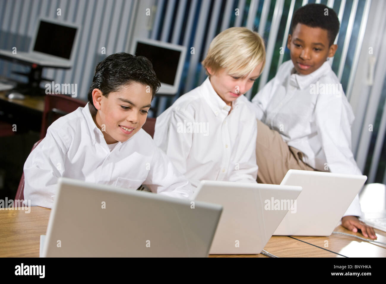Young multiracial boys with using laptop computers in school Stock ...