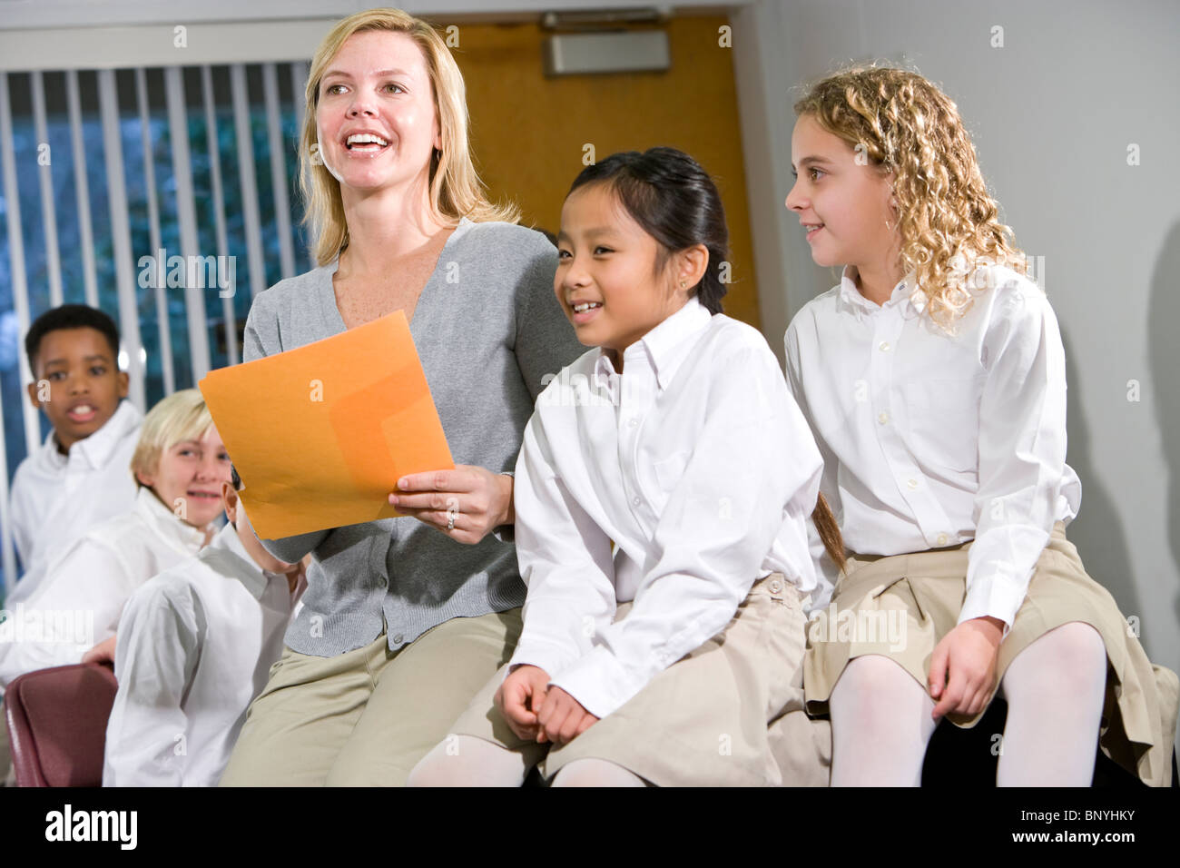 Teacher in classroom with group of elementary school children Stock ...