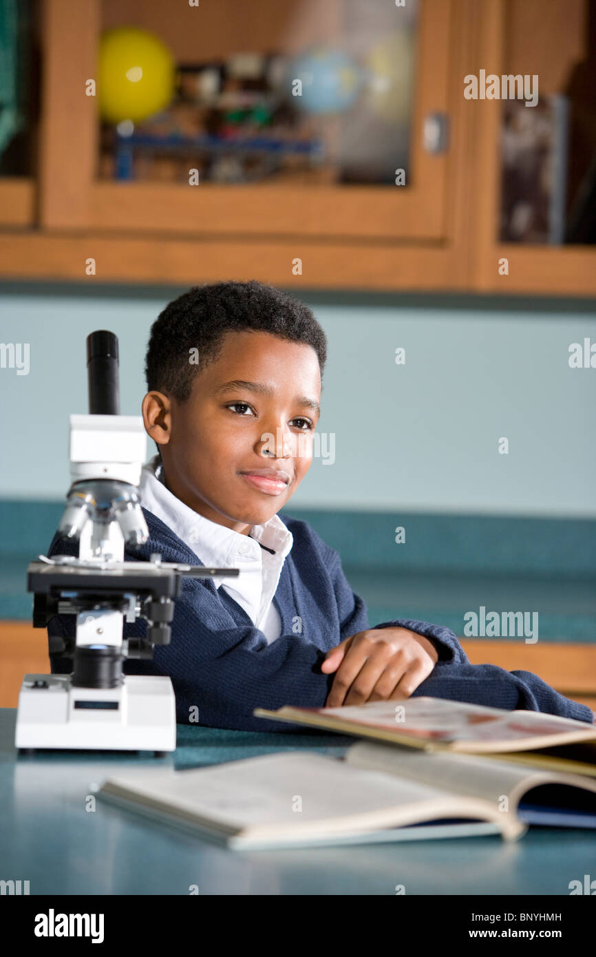 African American elementary school boy in science lab using microscope ...
