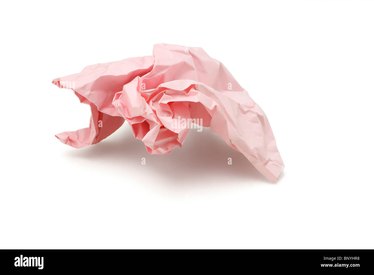 Crumbled pink colored paper discarded on white background Stock Photo ...