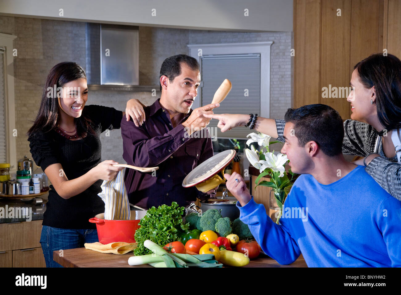 Hispanic family with teenage children cooking together in kitchen Stock ...
