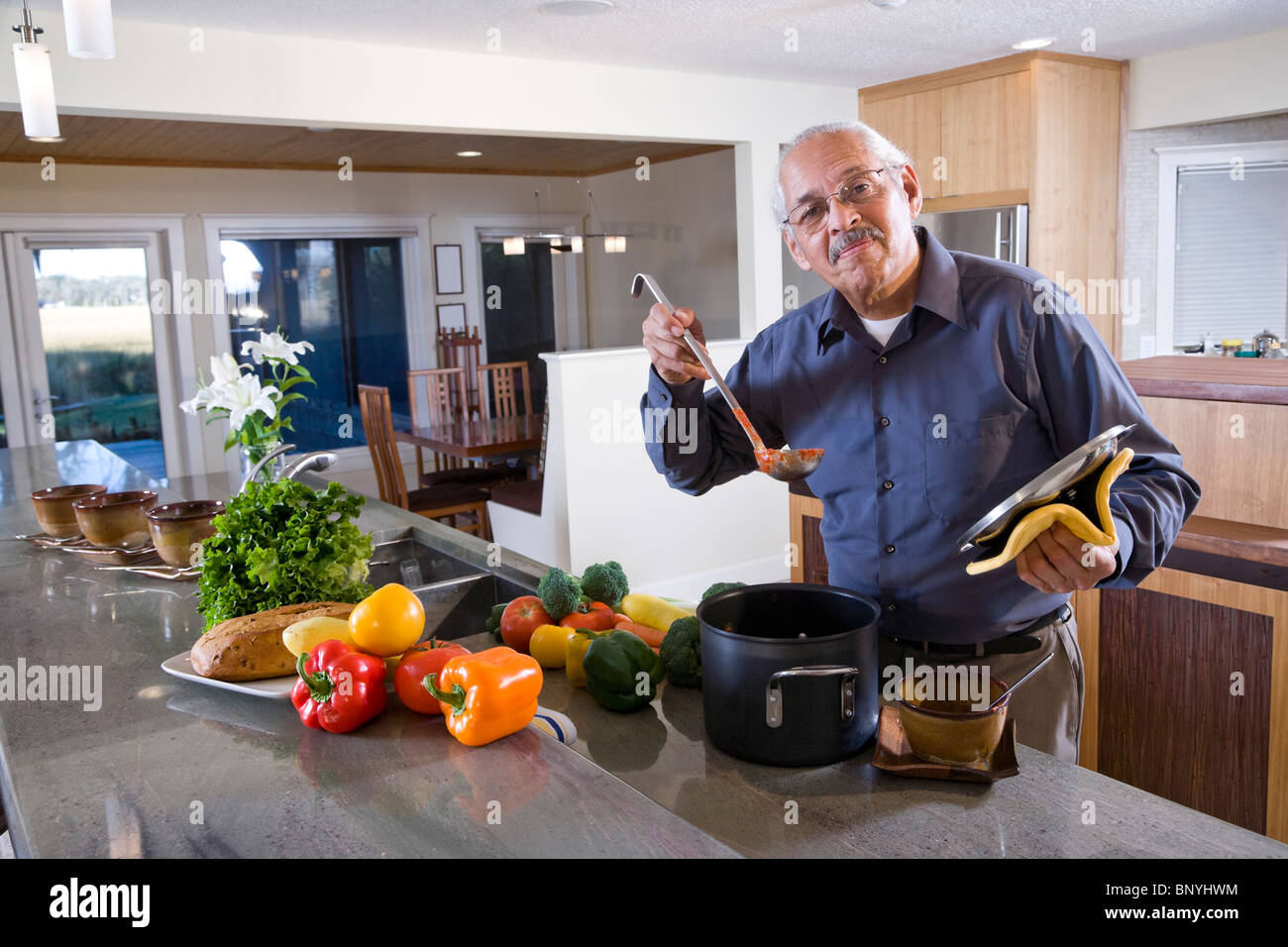 Senior Hispanic man in kitchen cooking healthy meal Stock Photo - Alamy