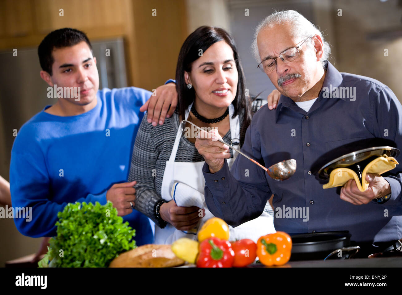 Three generation Hispanic family cooking in kitchen Stock Photo - Alamy