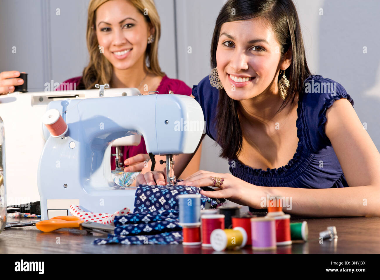 Young woman stitching fabric on sewing machine Stock Photo - Alamy