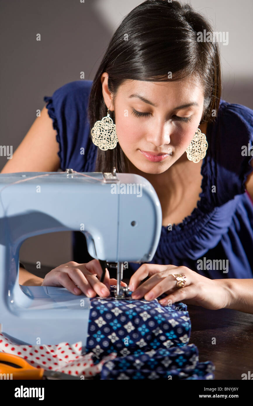 Young woman stitching fabric with sewing machine Stock Photo - Alamy