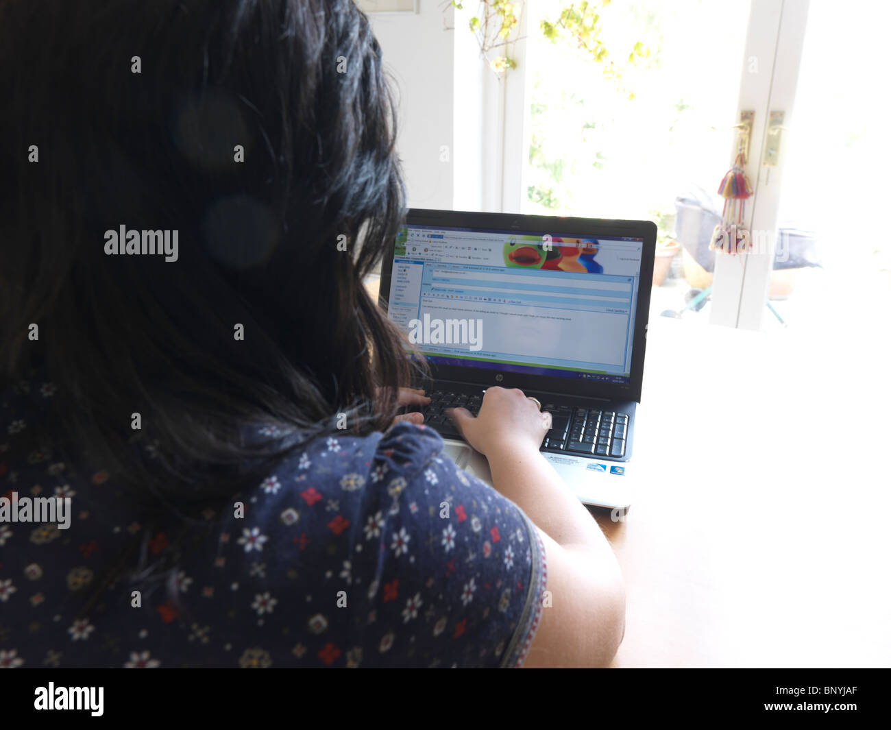 A teenage girl writing an e-mail on a laptop England Stock Photo - Alamy