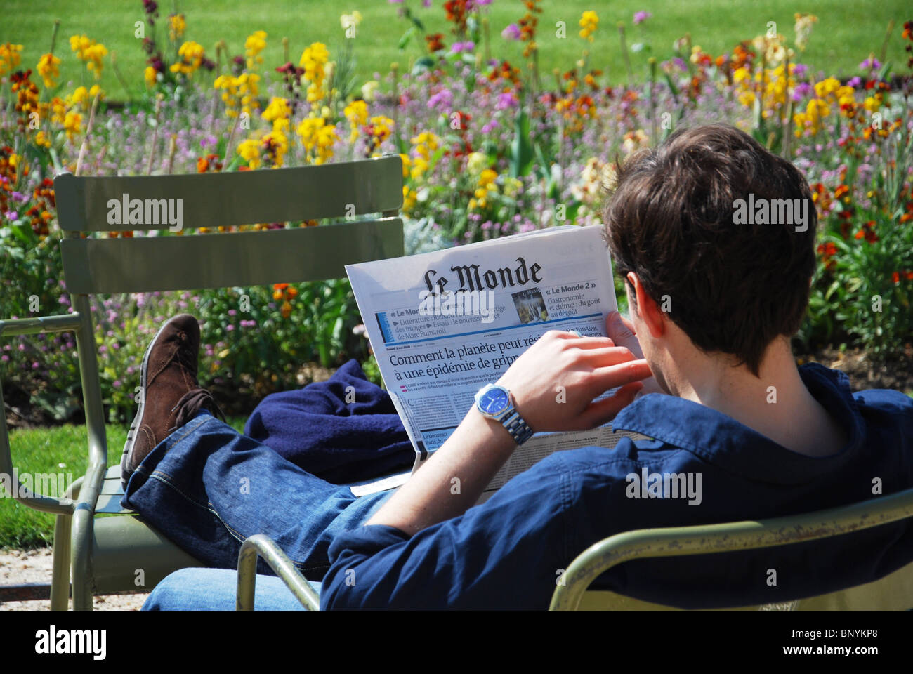 man reading Le Monde newspaper in sunny Paris, Jardin du Luxembourg ...