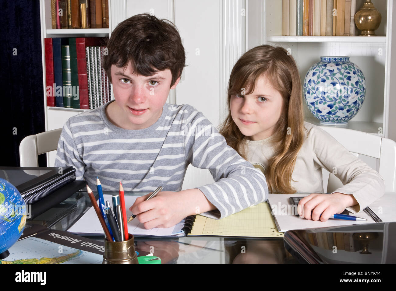 Two teenager kids doing their homework together Stock Photo - Alamy