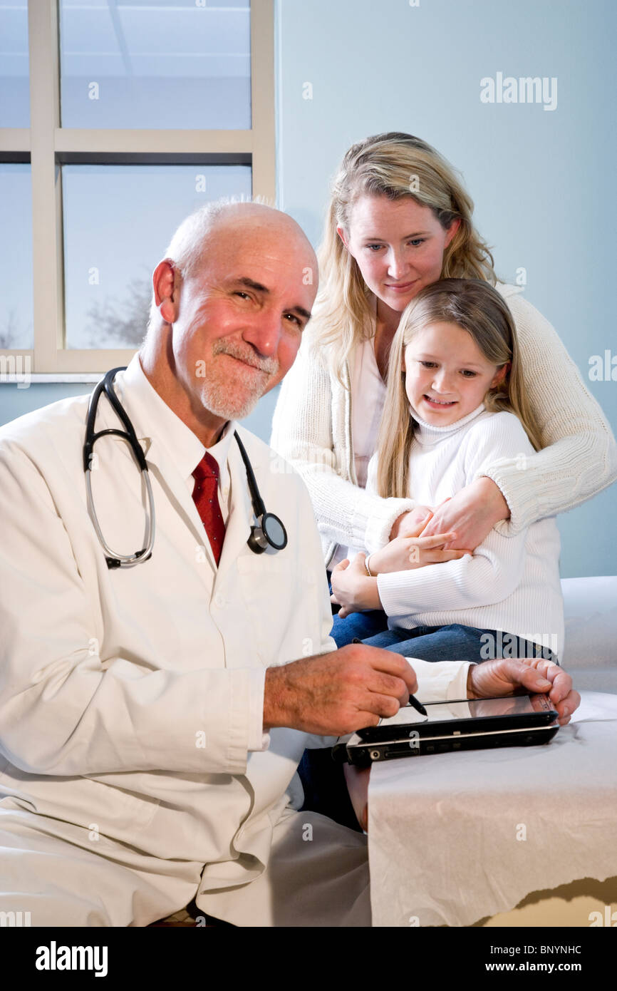 Pediatrician with child patient and mother in background Stock Photo ...