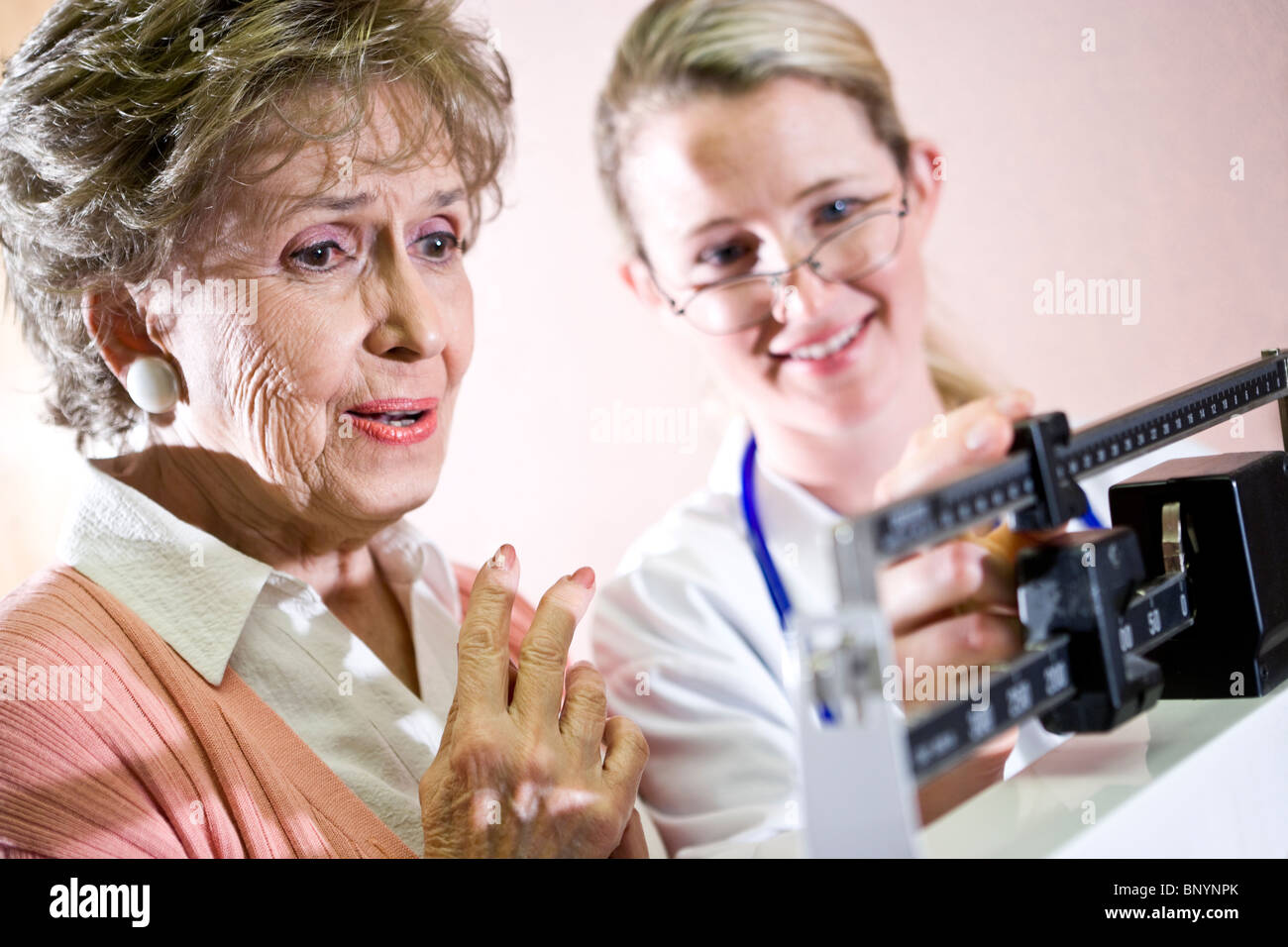 Senior woman checking weight in doctor's office Stock Photo - Alamy
