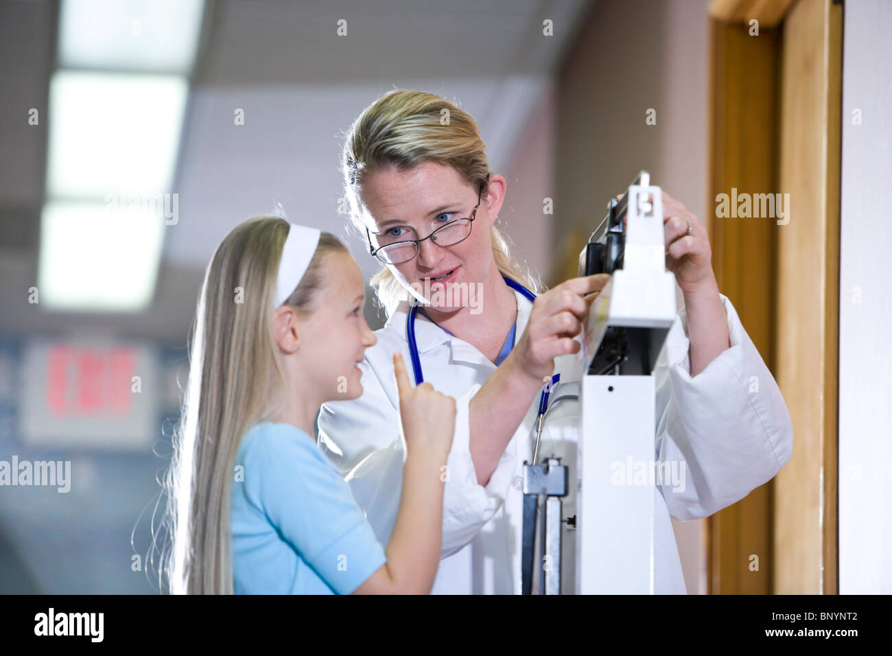 Female healthcare worker weighing child on scale Stock Photo - Alamy